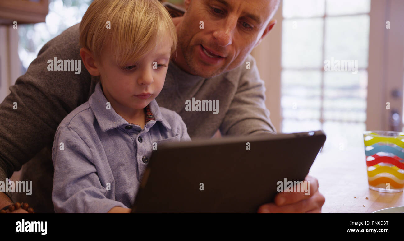 Adorable young white boy learning to use tablet computer Stock Photo ...