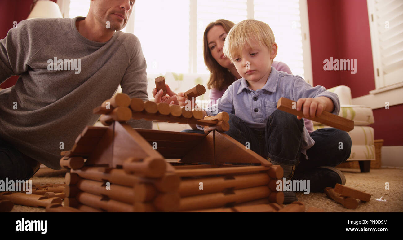 Adorable young children building a wooden house with family Stock Photo ...