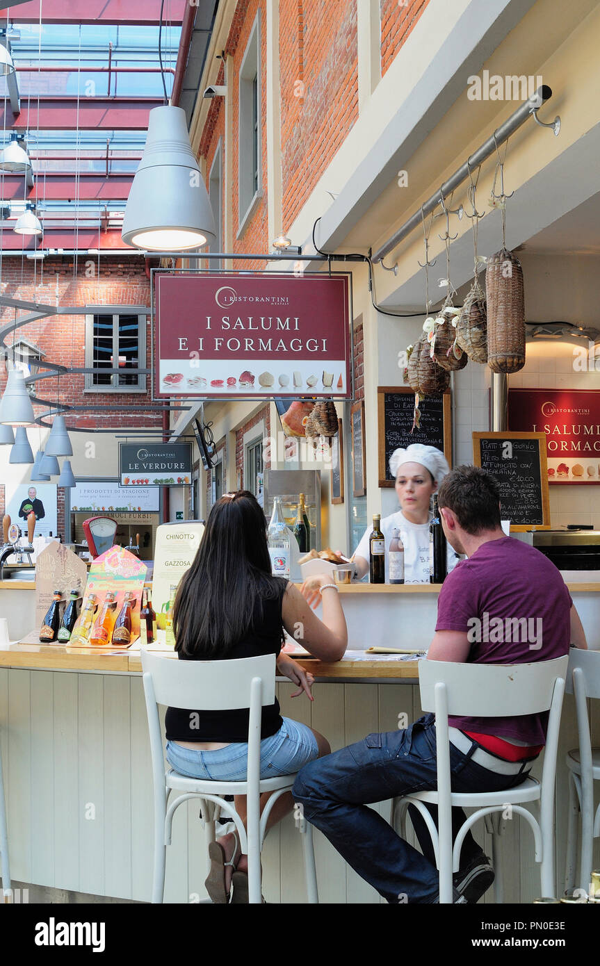 Italy, Piedmont, Turin, couple dining at bar at Eataly, Slow Food store ...