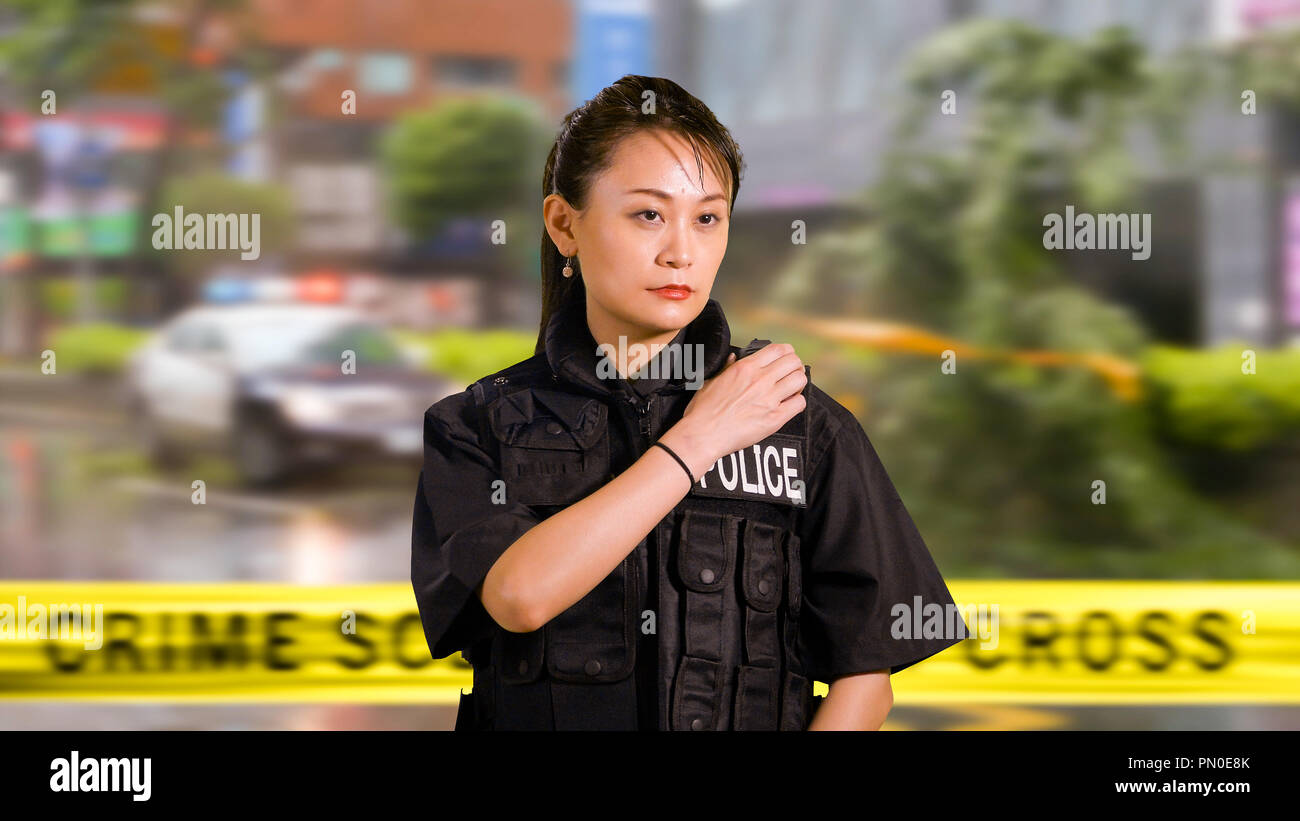 Asian American Woman Police Officer at Crime scene Calling for Backup ...
