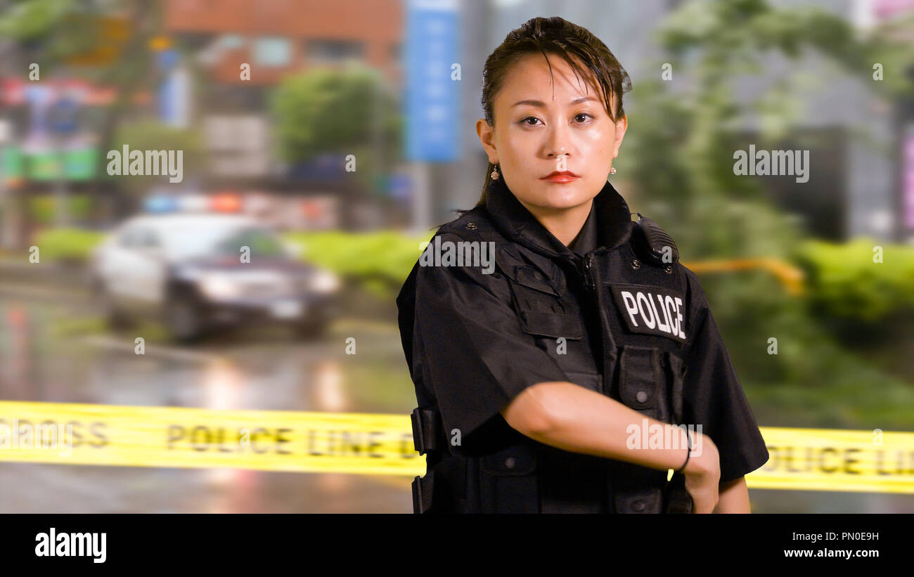 Asian American Woman Police Officer at Crime scene Pulling Gun out of ...
