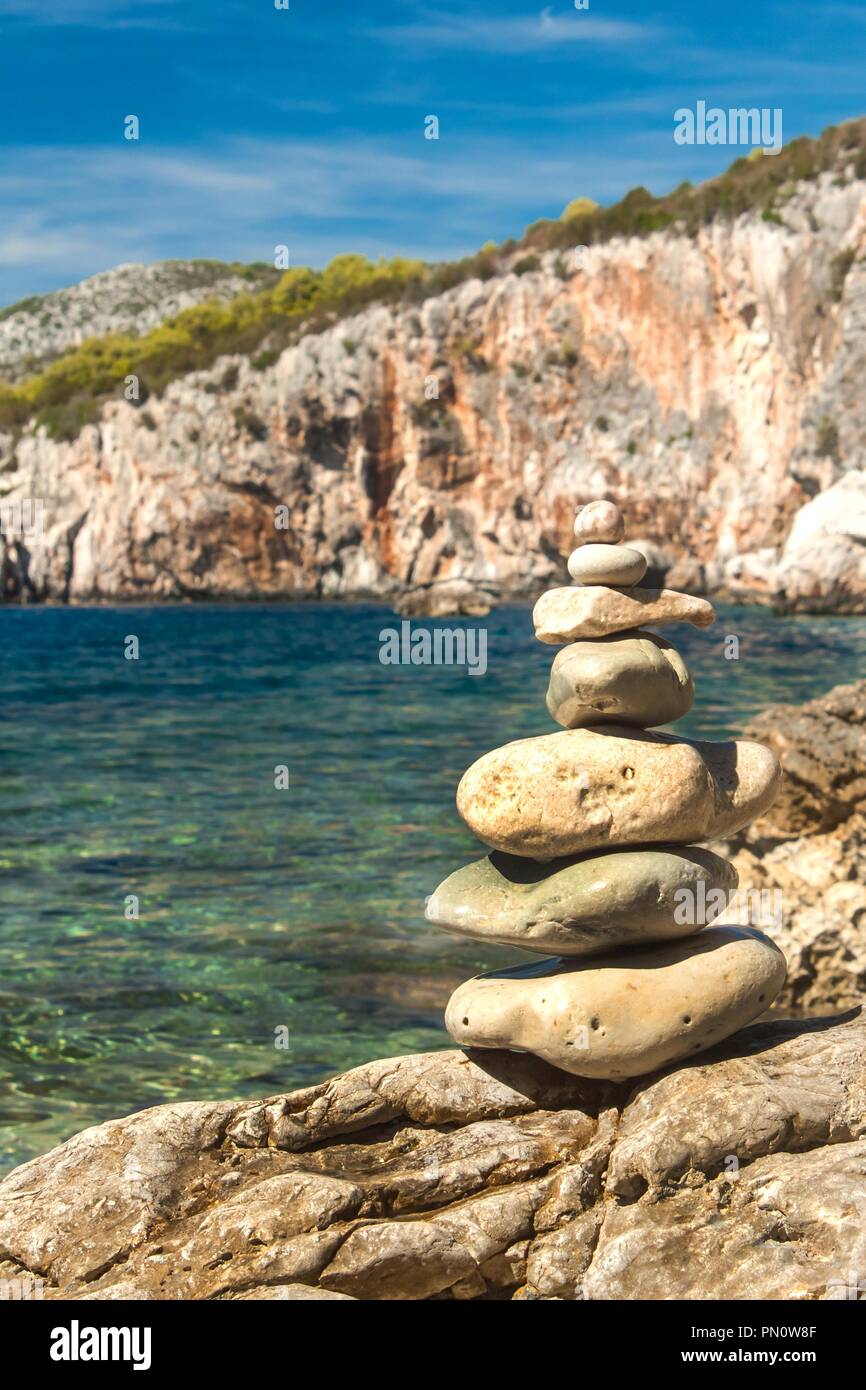 Pile of pebbles on the sea front on a beautiful day. Pebble stack on ...