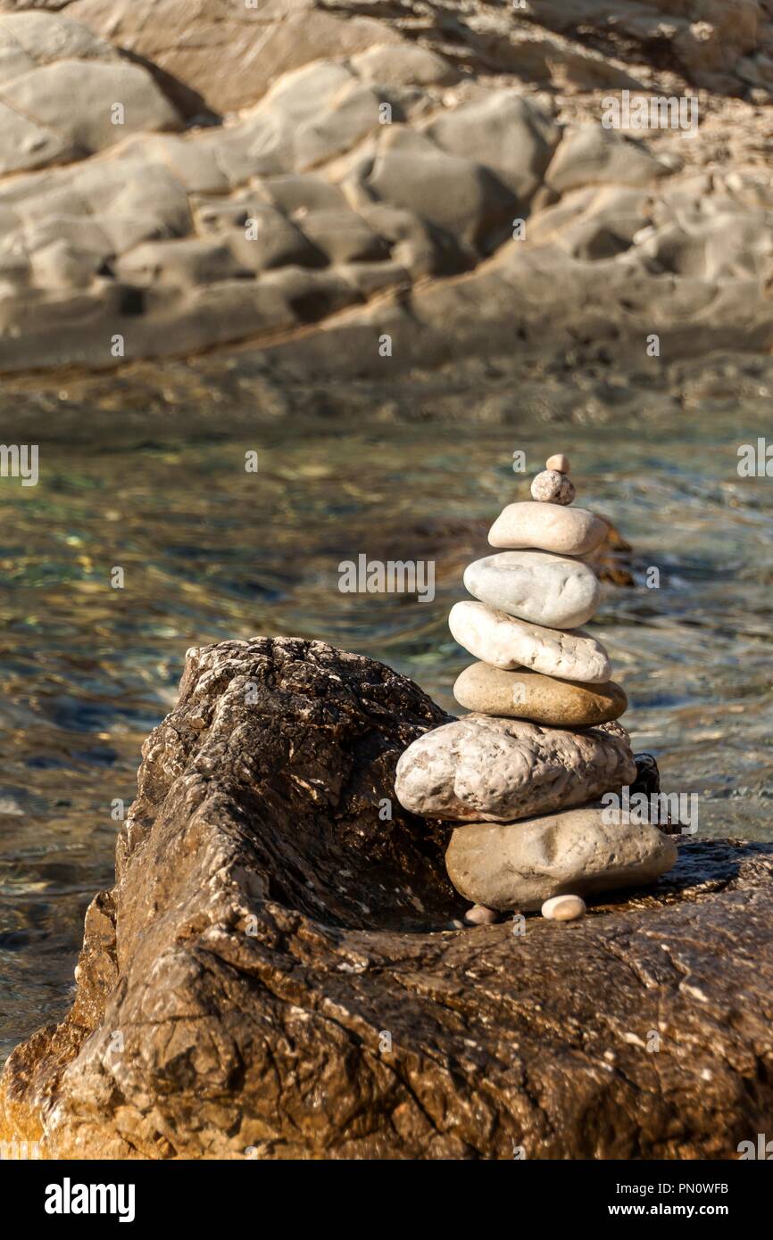 Pile of pebbles on the sea front on a beautiful day. Pebble stack on ...