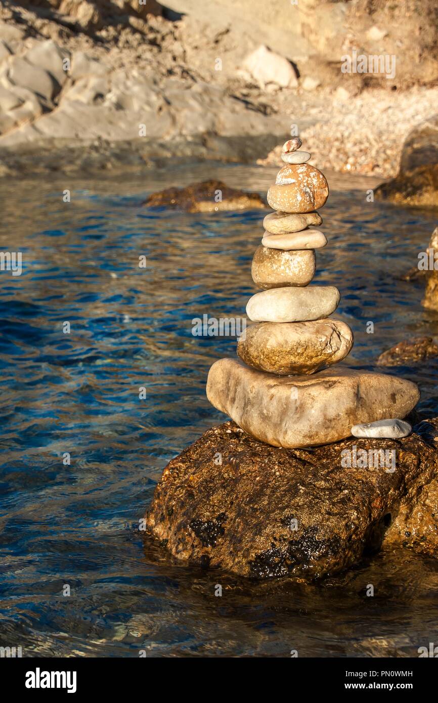Pile of pebbles on the sea front on a beautiful day. Pebble stack on ...