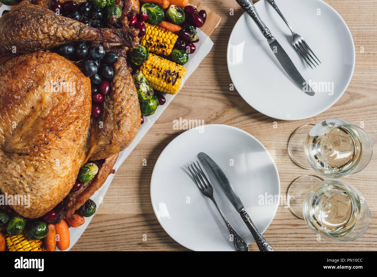 flat lay with roasted turkey, vegetables and glasses of wine for ...