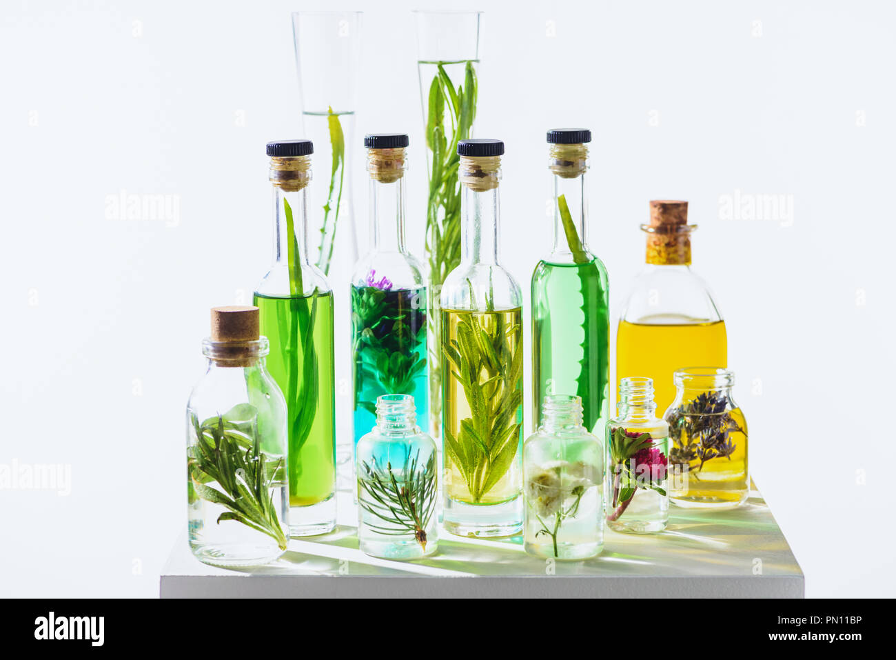different glass bottles of natural herbal essential colored oils on ...