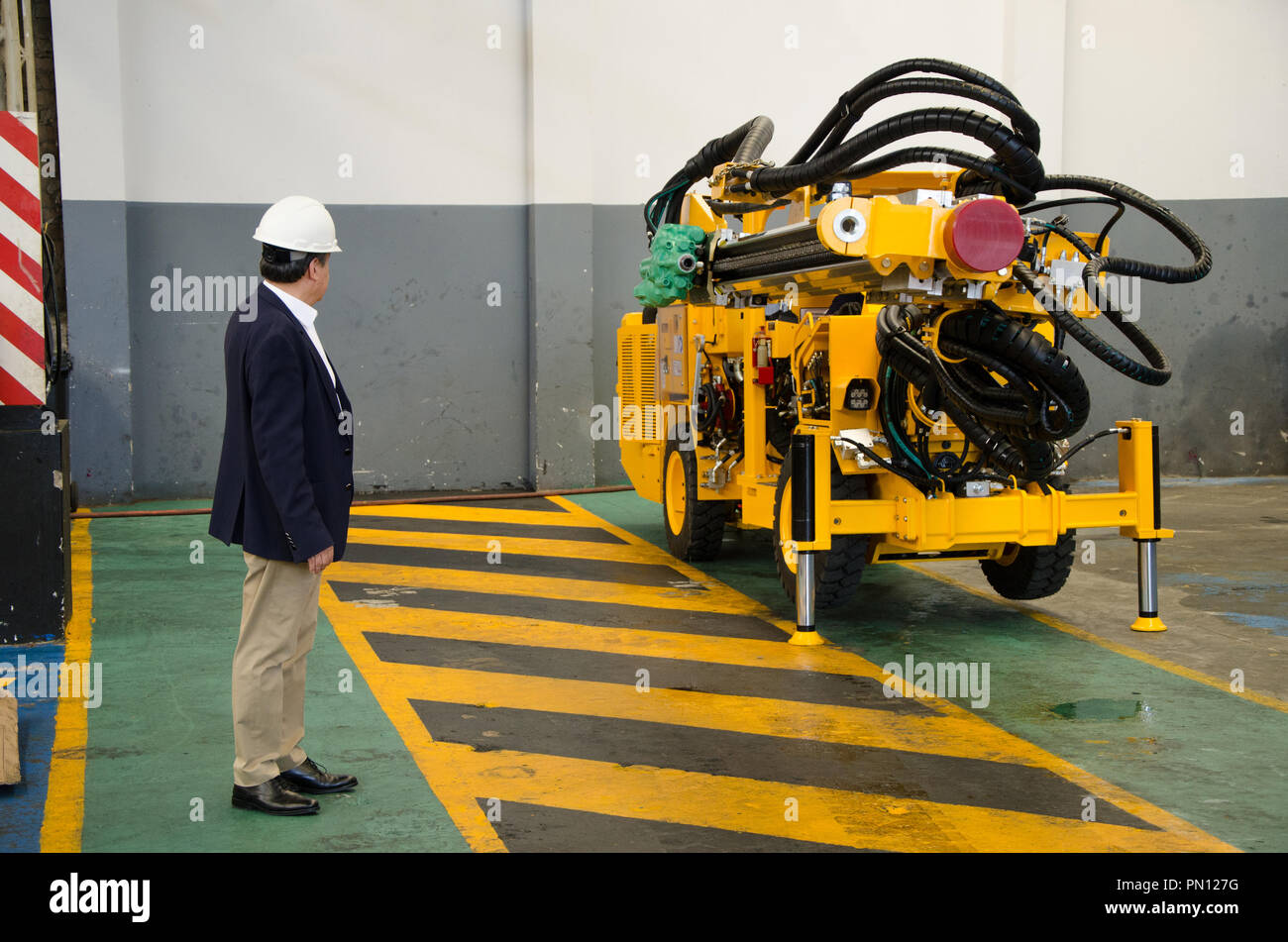 Businessman from behind looking at the mine machine in a factory Stock ...