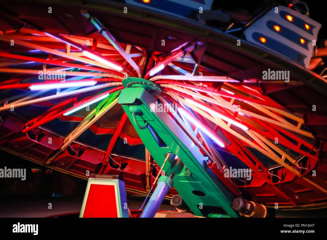An illuminated rotating circular device in an amusement park Stock ...