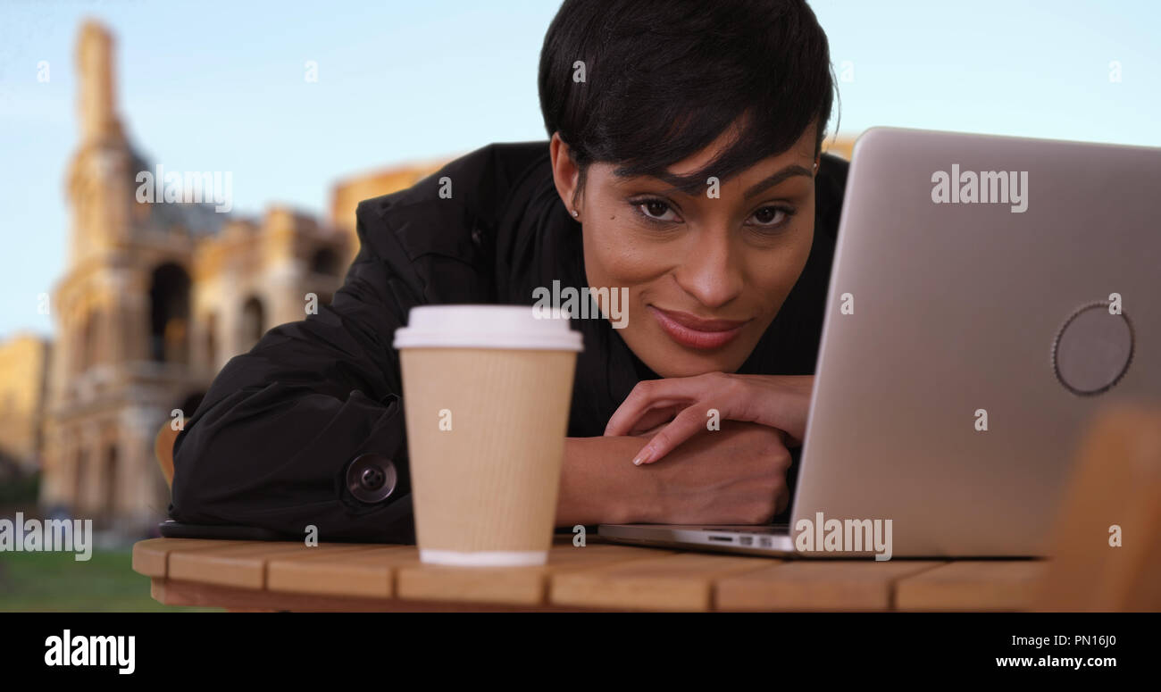 Stunning black woman with laptop stares intently at camera near Roman ...