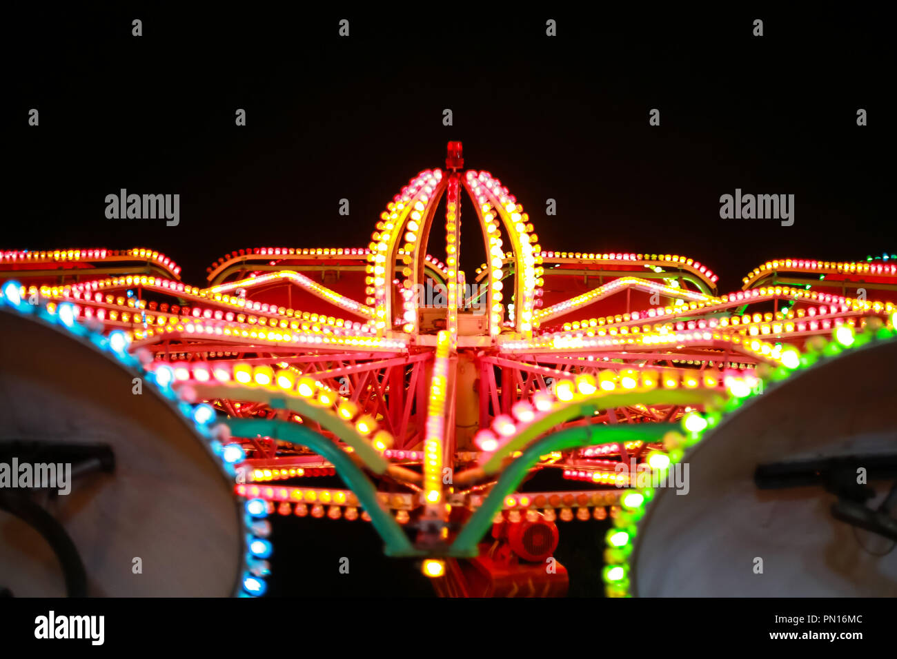An illuminated rotating circular device in an amusement park Stock ...