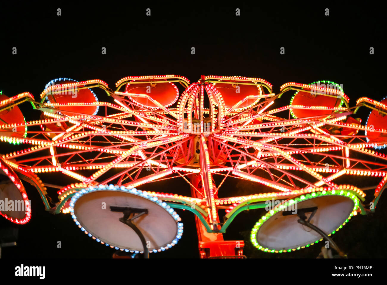 An illuminated rotating circular device in an amusement park Stock ...