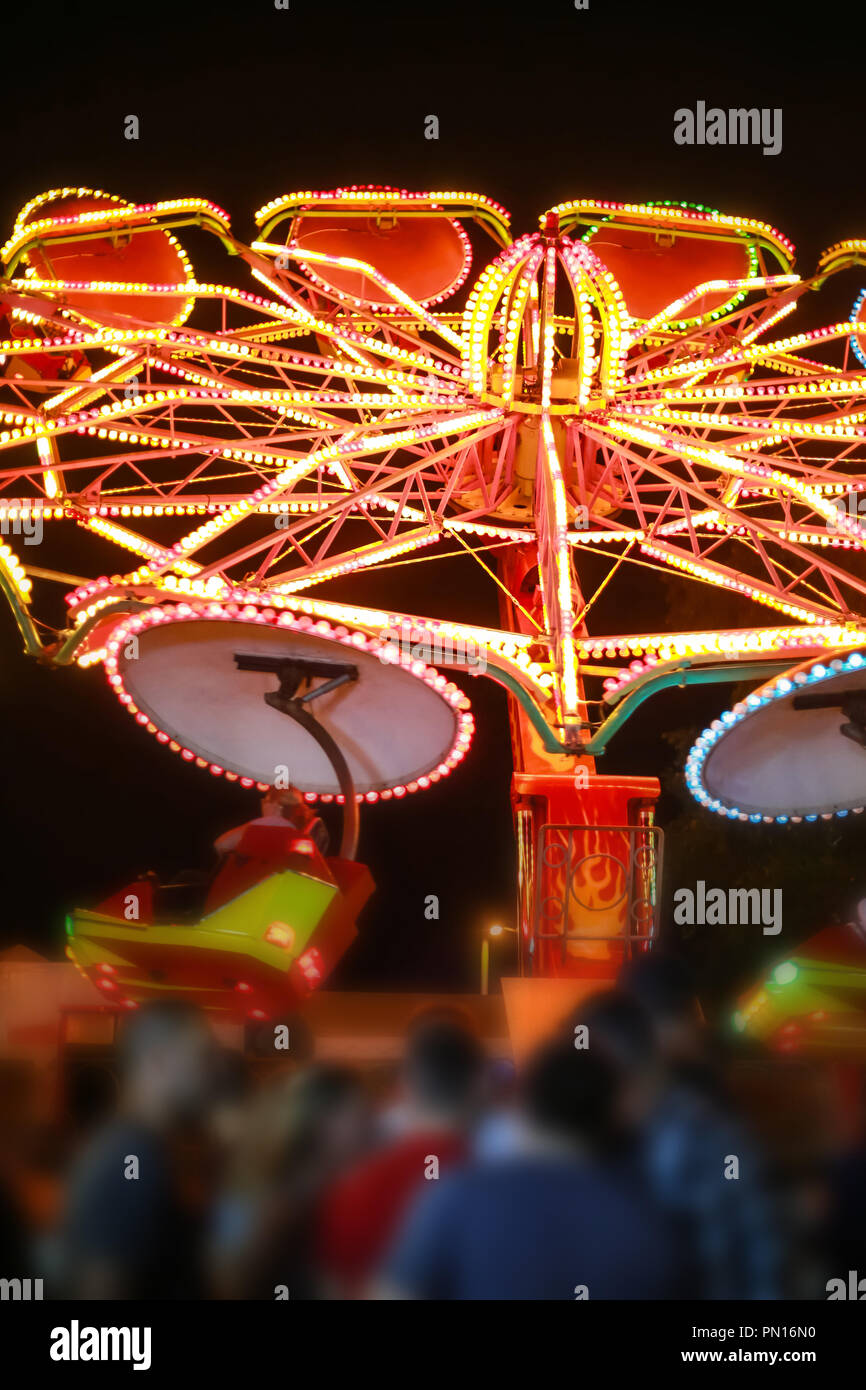 An illuminated rotating circular device in an amusement park Stock ...