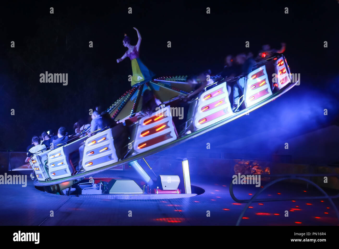 An illuminated rotating circular device in an amusement park Stock ...