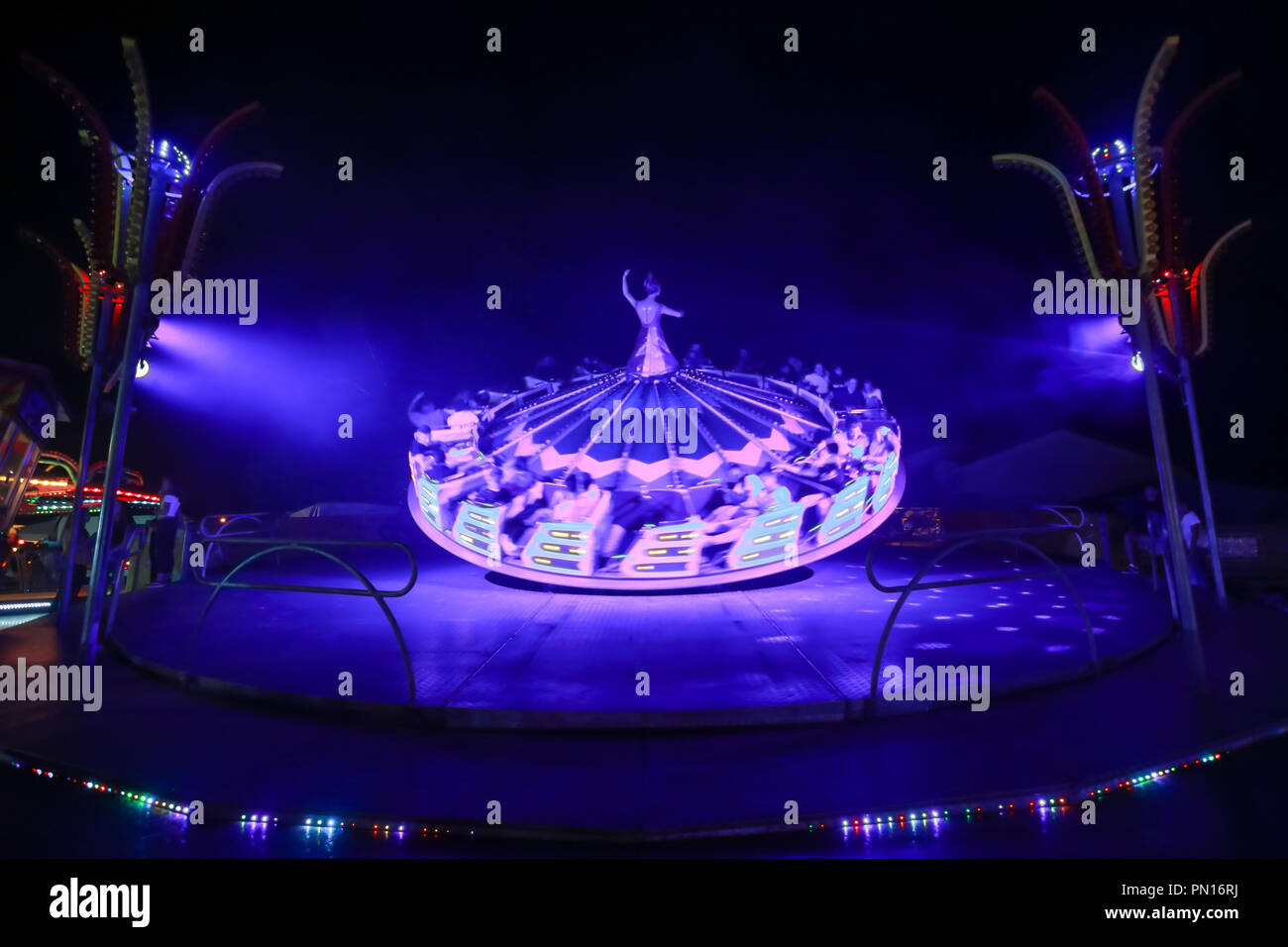 An illuminated rotating circular device in an amusement park Stock ...