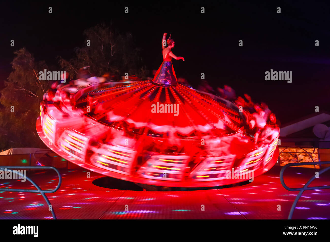 An illuminated rotating circular device in an amusement park Stock ...