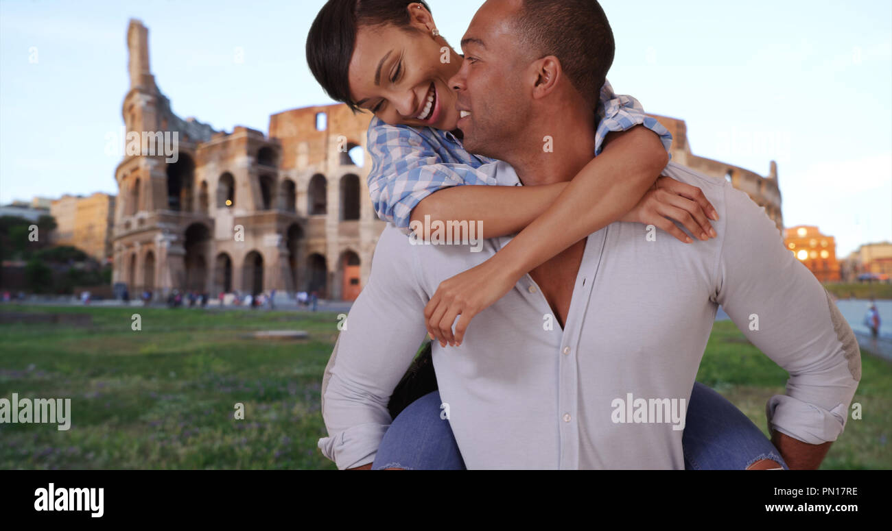 Pretty ethnic female secretly jumps on boyfriends back by the Roman ...