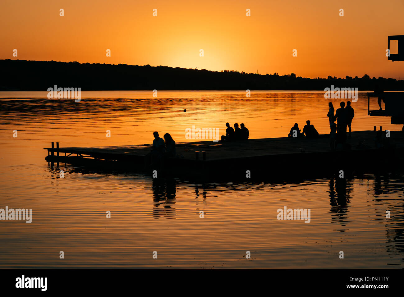People rest on the river bank. Sunset Stock Photo - Alamy