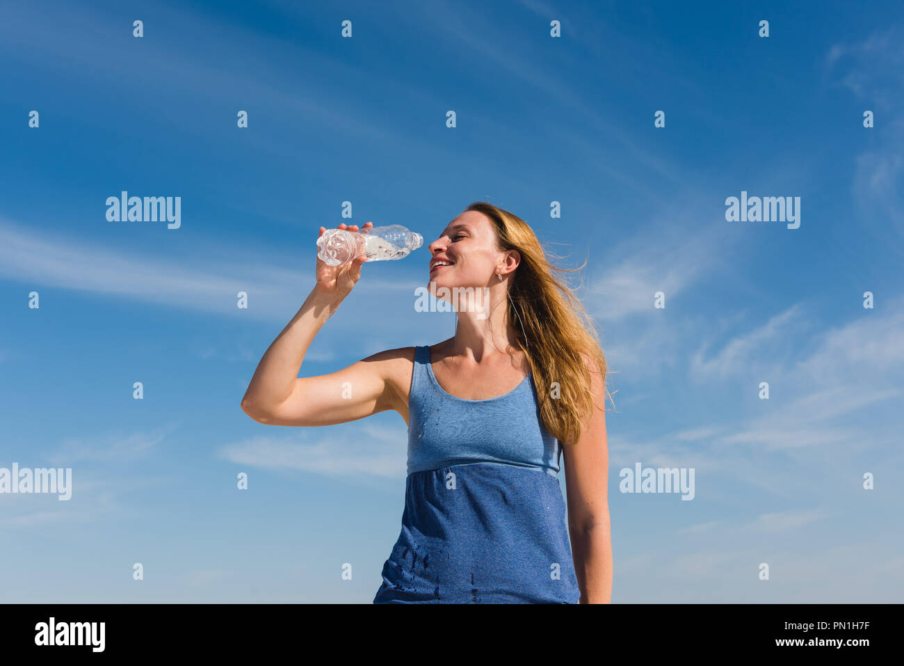Attractive female drink water from bottle outdoors Stock Photo - Alamy