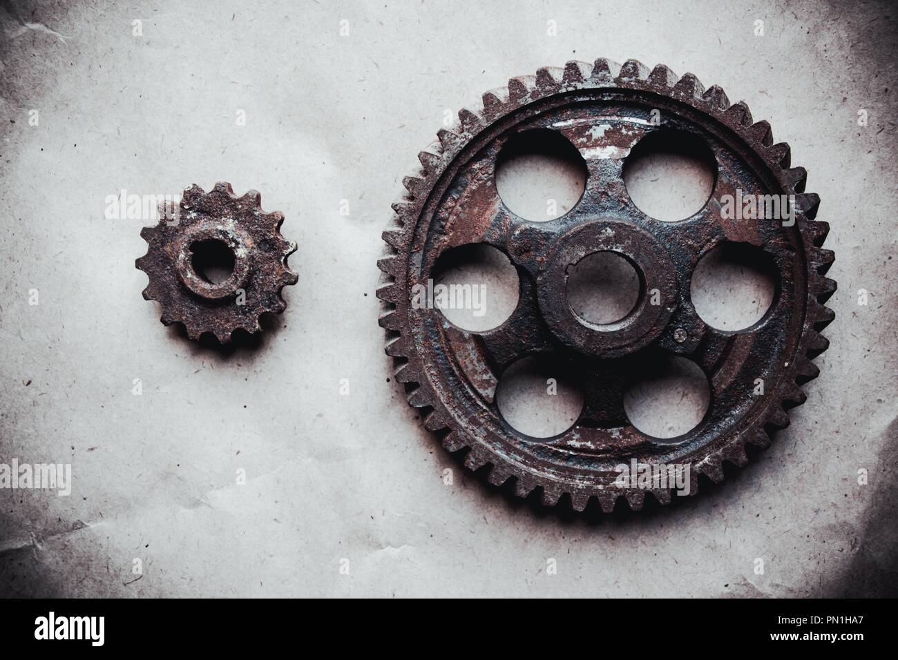 Two parts of the mechanism are made of metal lying on a paper surface ...