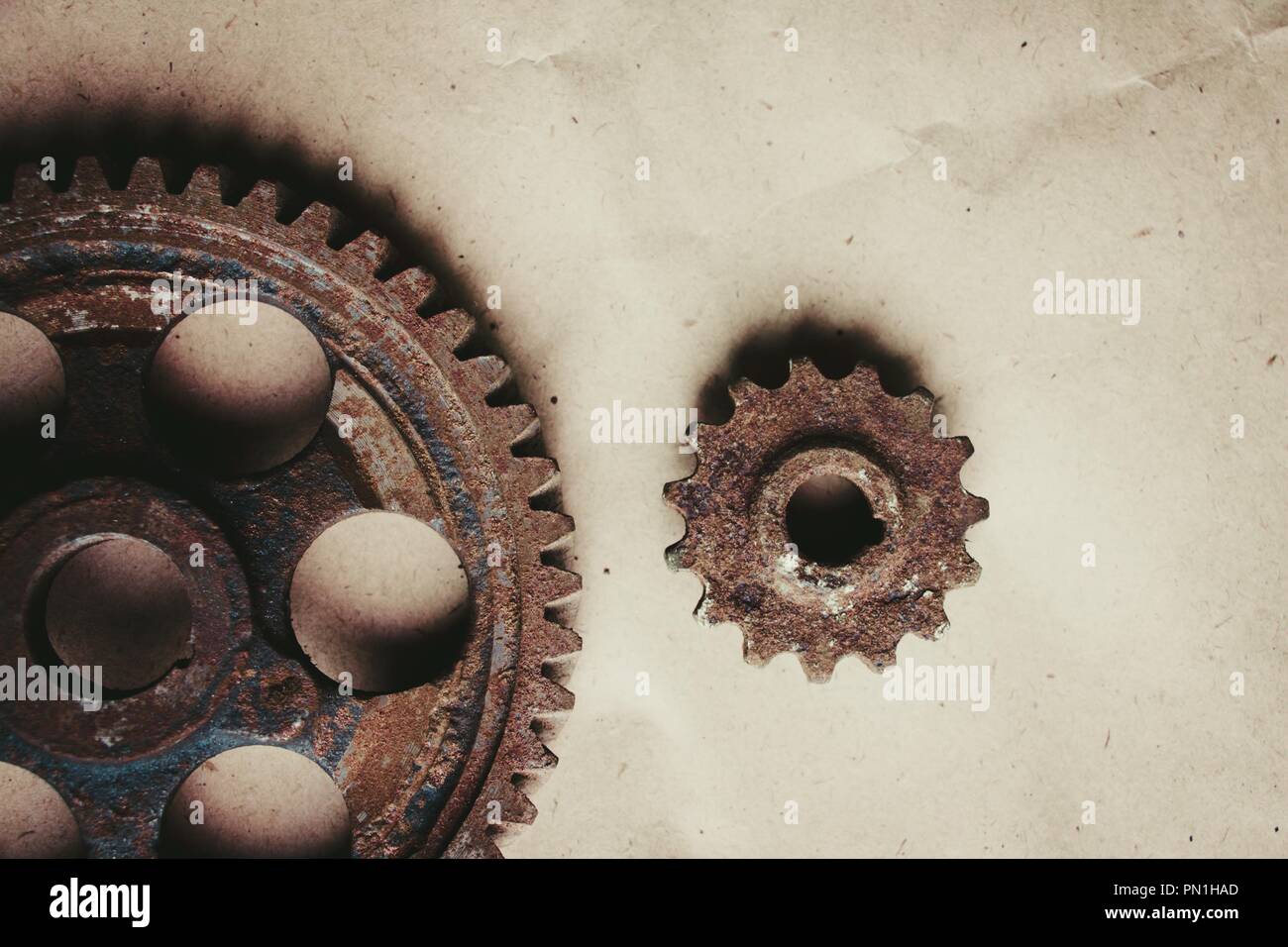 Two parts of the mechanism are made of metal lying on a paper surface ...