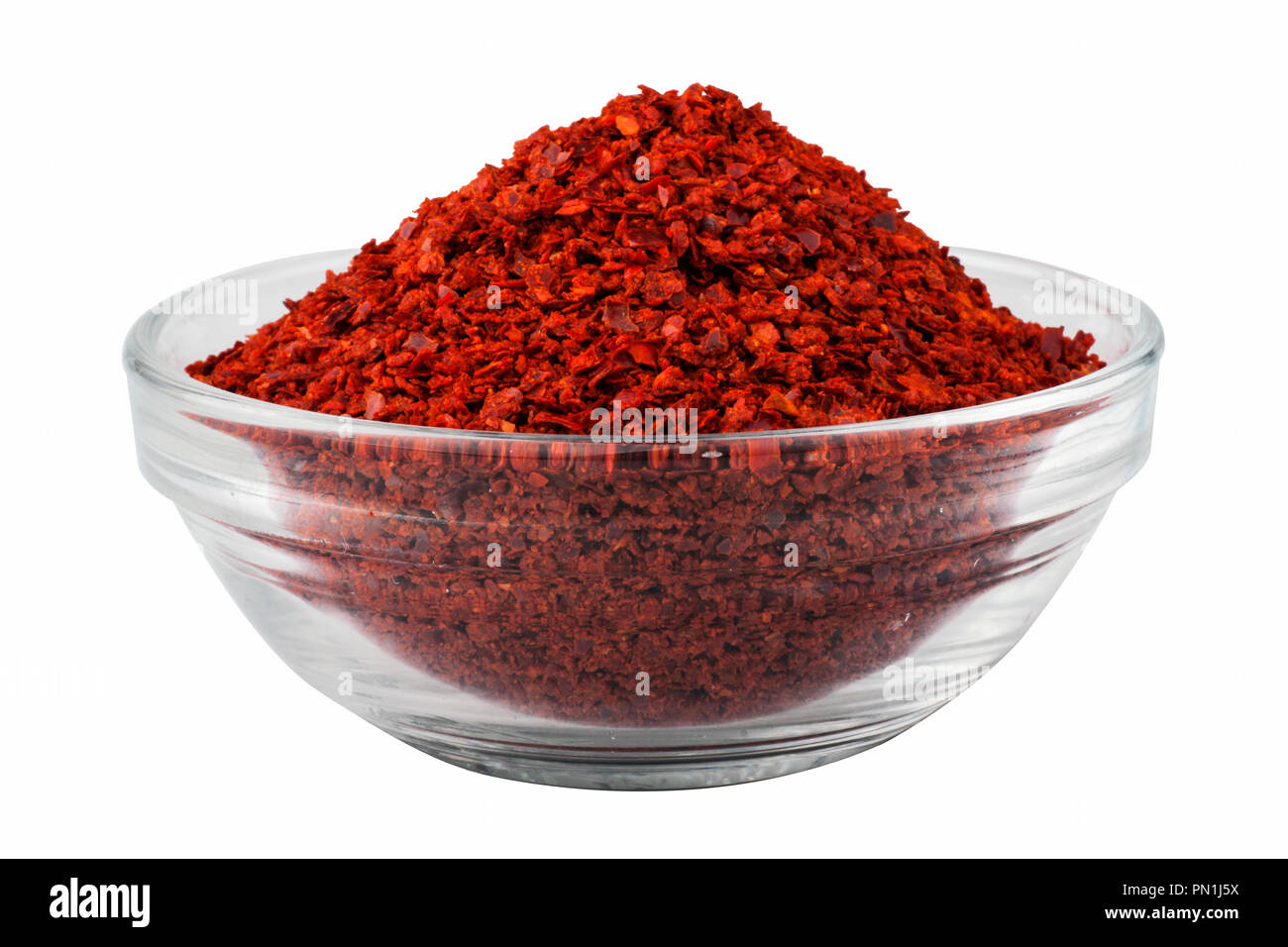 Dried red pepper, chilli flakes in a glass bowl, isolated on white ...