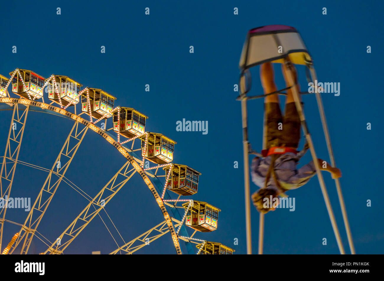 swingboat ride and ferris wheel at Oktoberfest in Munich Germany Stock ...