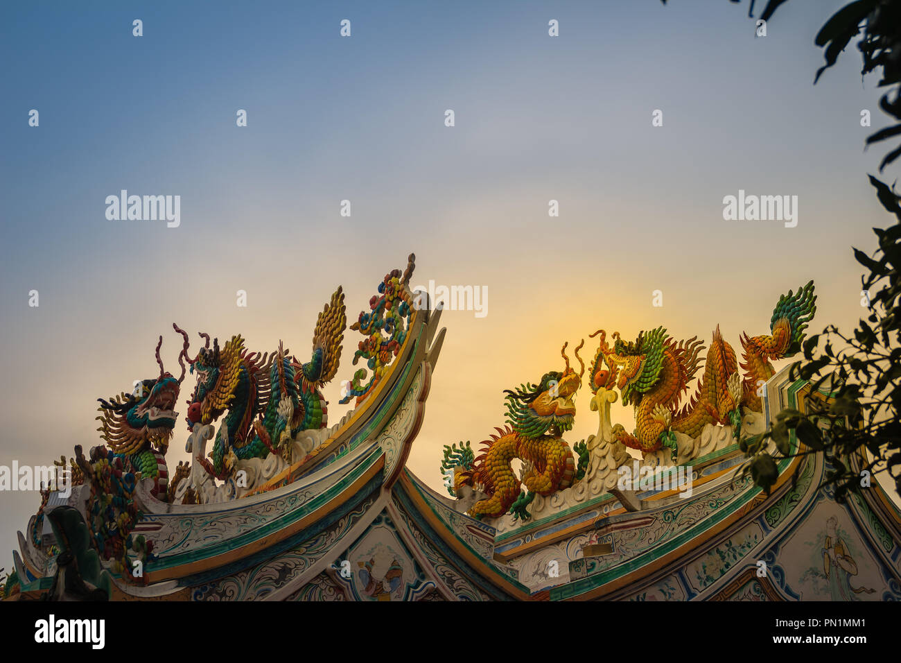 Beautiful large grimace dragons crawling on the decorative tile roof in ...