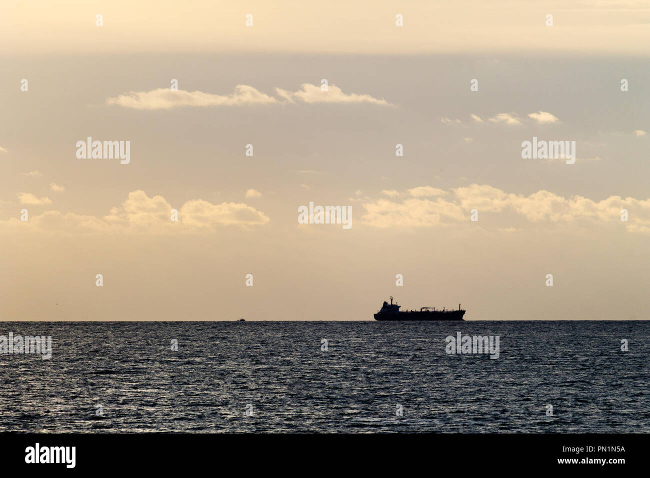 A distant cargo ship is seen on the ocean at the horizon Stock Photo ...