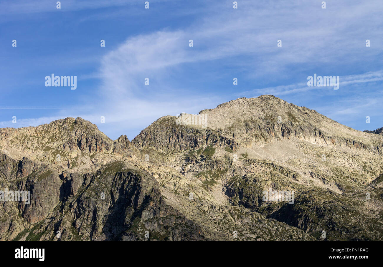 A curve shaped cloud is formed behind the rocky mountains Stock Photo ...