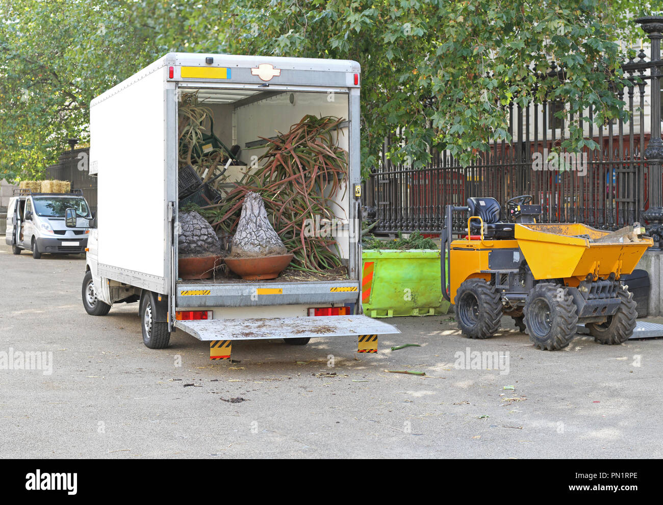 Skip Loading Dumper and Truck Loaded With Plants Stock Photo - Alamy