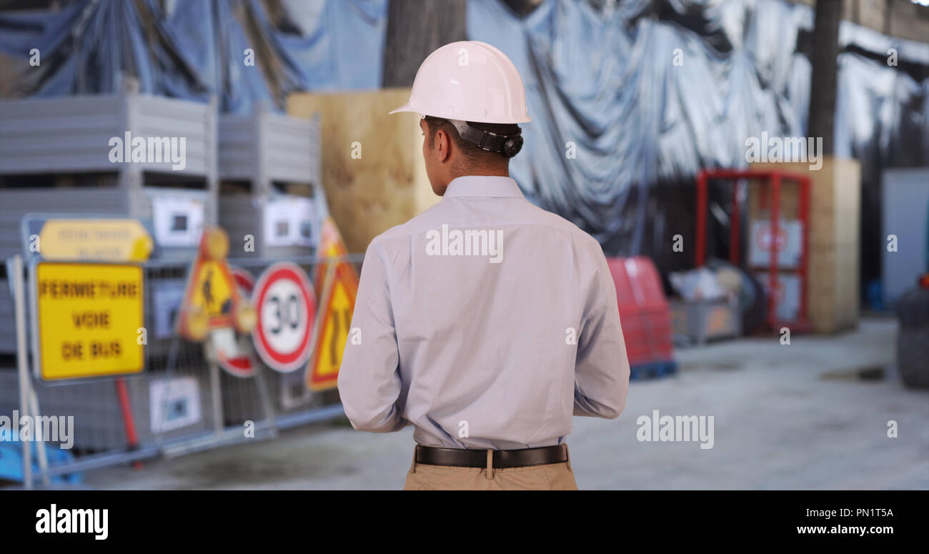 Rear view of attractive and professional contractor using high-tech ...