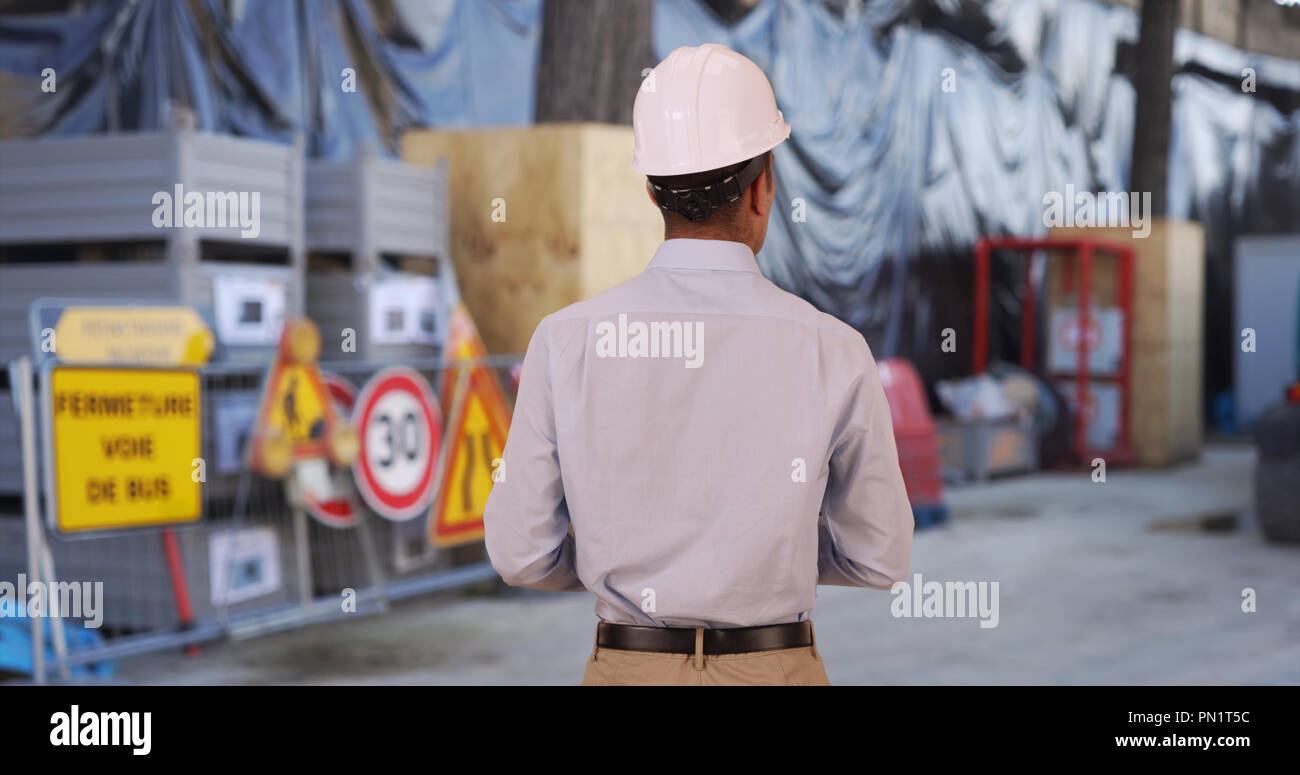 Rear view of attractive and professional contractor using high-tech ...