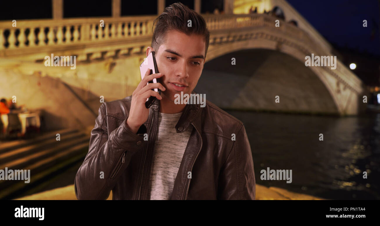 Happy attractive millennial guy answers cellphone near Rialto Bridge at ...