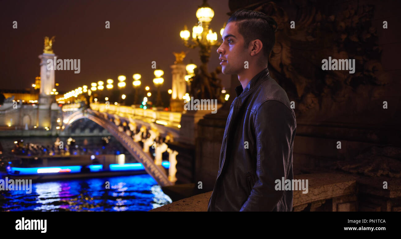 Cute Hispanic guy standing by famous Pont Alexandre III bridge at night ...