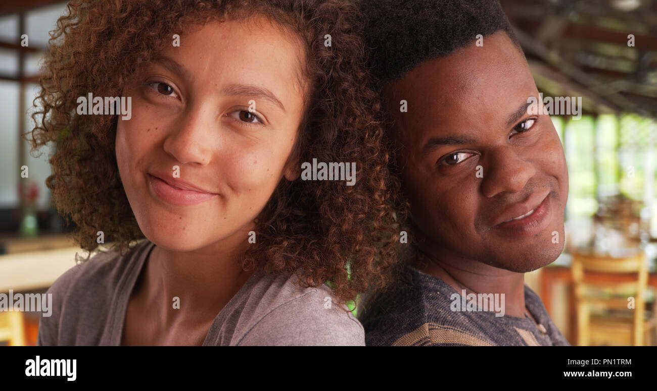 Happy smiling African American man and woman lean on each other as they ...
