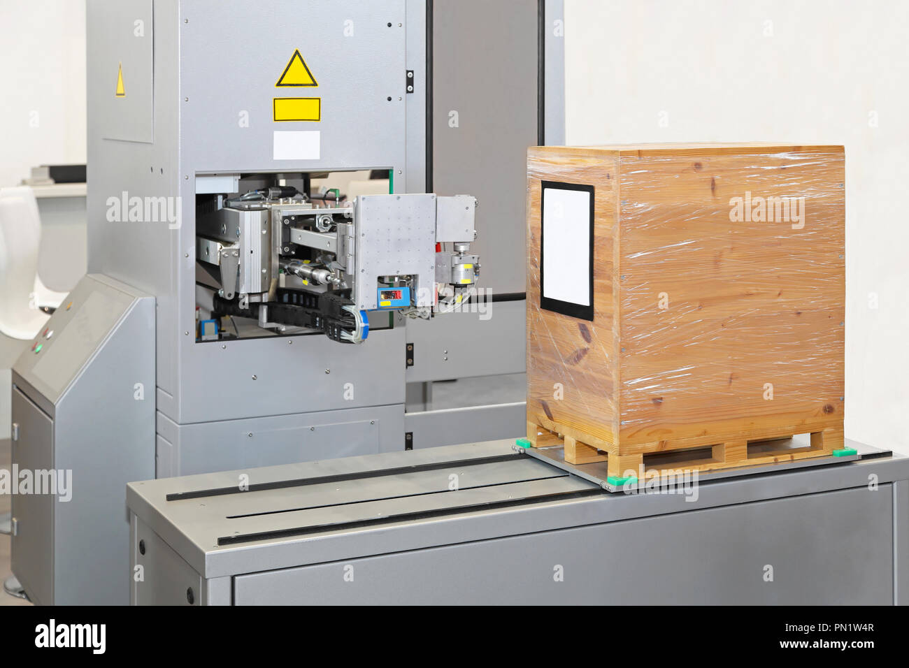 Automated labeling machine at production line in factory Stock Photo ...