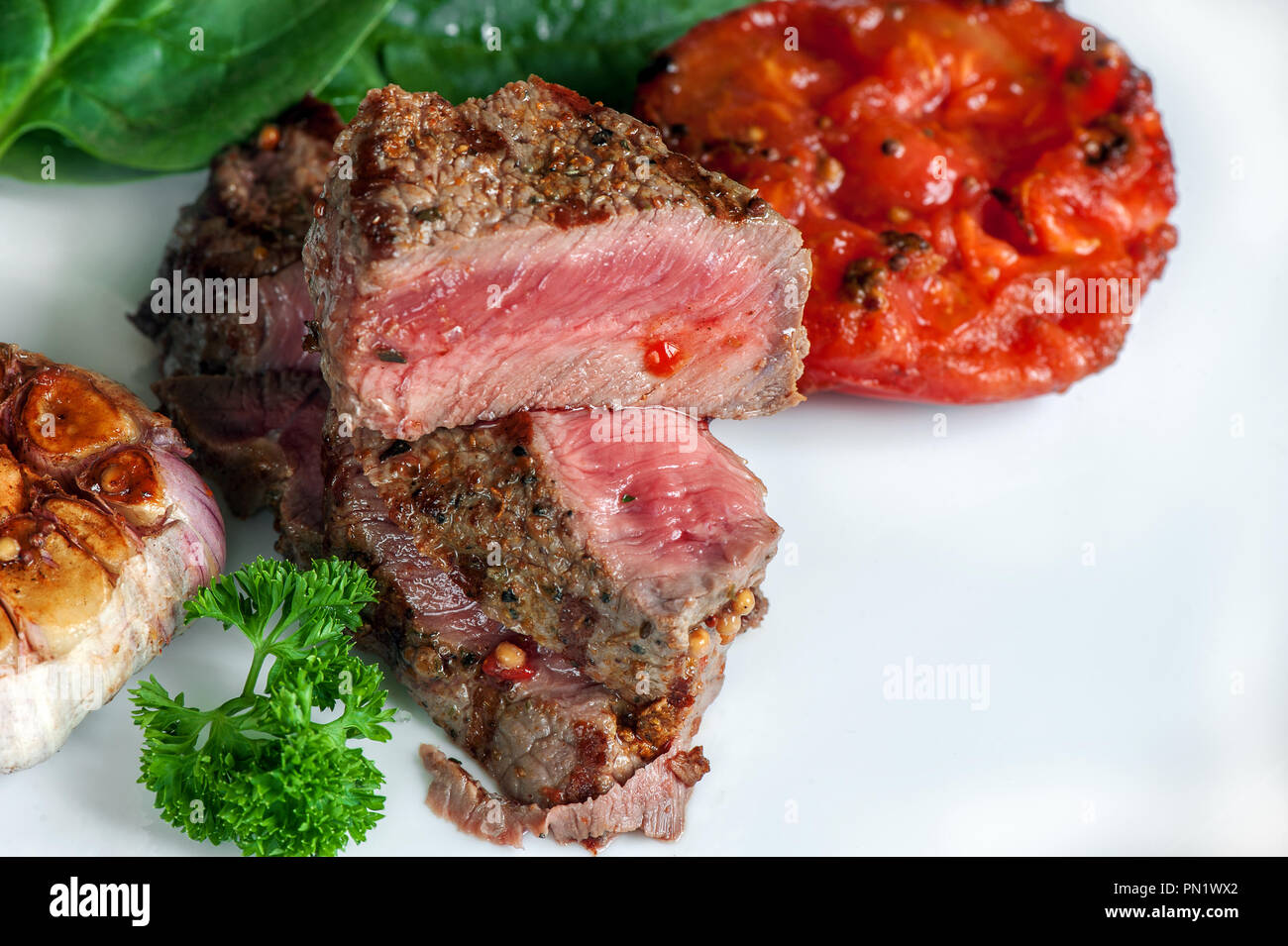 Steak with blood medium rare with a side dish of tomatoes and ...