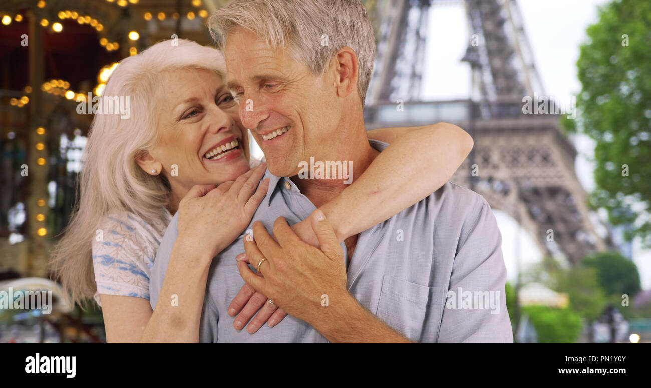 Affectionate Senior Husband And Wife Embracing Near The Eiffel Tower
