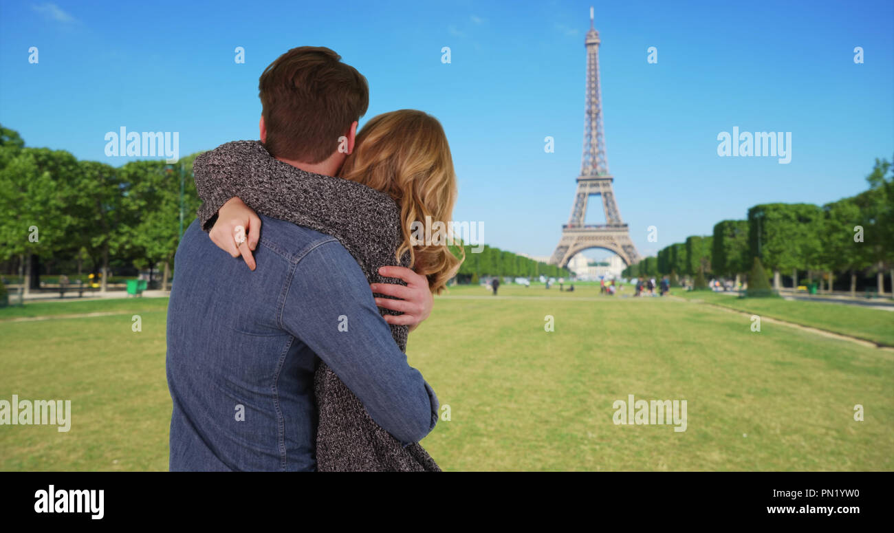 Rear view of young married couple gazing at the Eiffel Tower in Paris ...