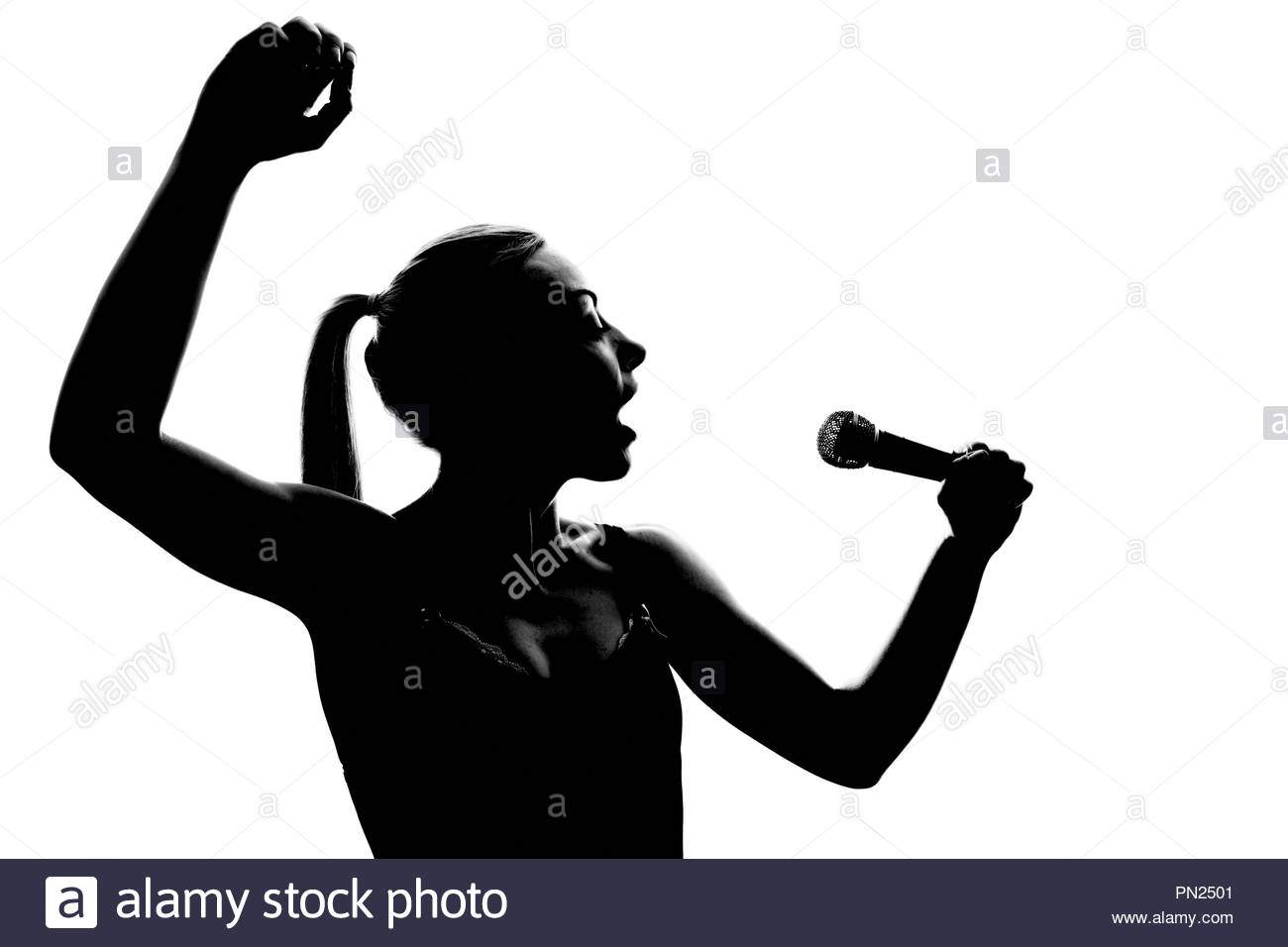 Woman with ponytail singing into microphone Stock Photo - Alamy