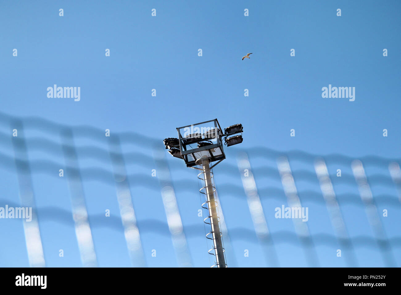 Stadium floodlight tower with reflectors with blue sky. Lighting pole ...