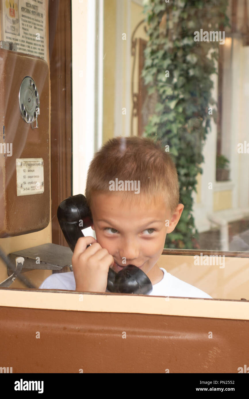 A boy in a blue shirt calling on the retro phone. Boy with an old ...