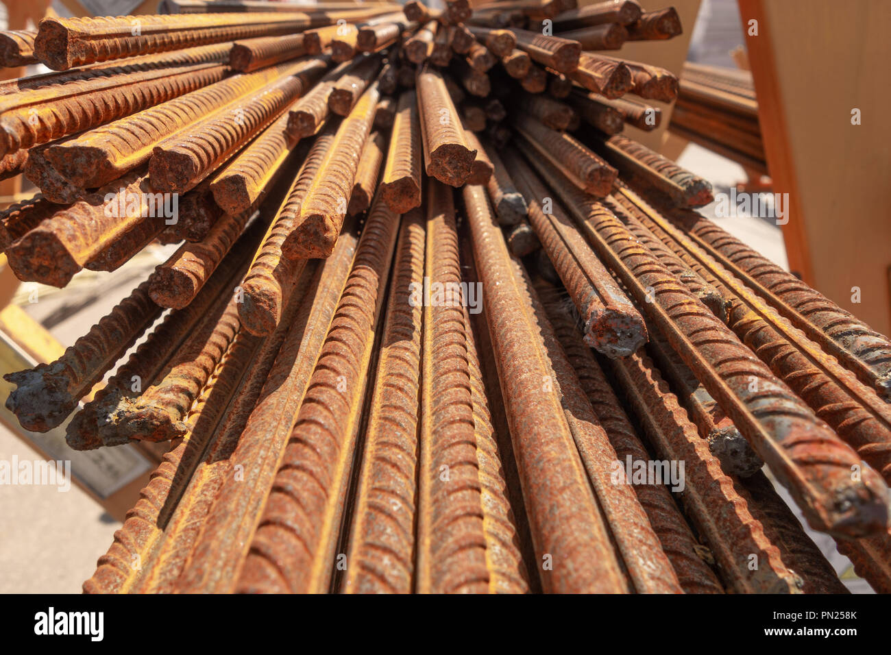 Rusty metal rolled steel lies on a rack in the open air on a bright ...