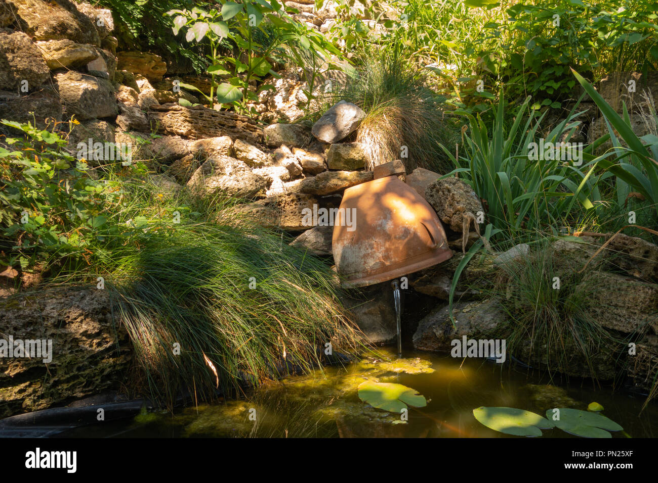 Broken jug water feature with vase Stock Photo - Alamy