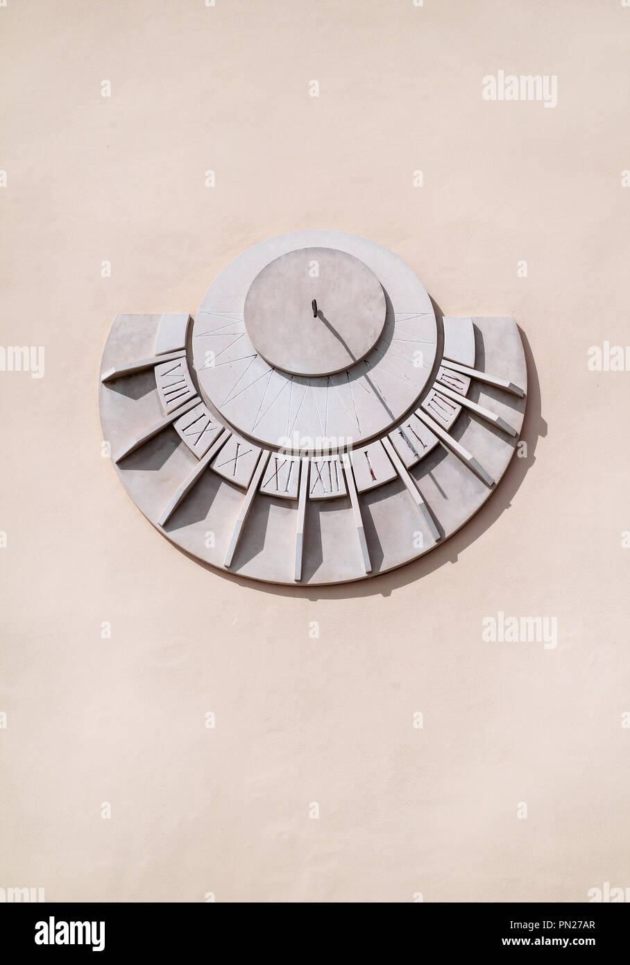 Old solar clock on a white wall, close up. Old fashioned sun dial on a ...