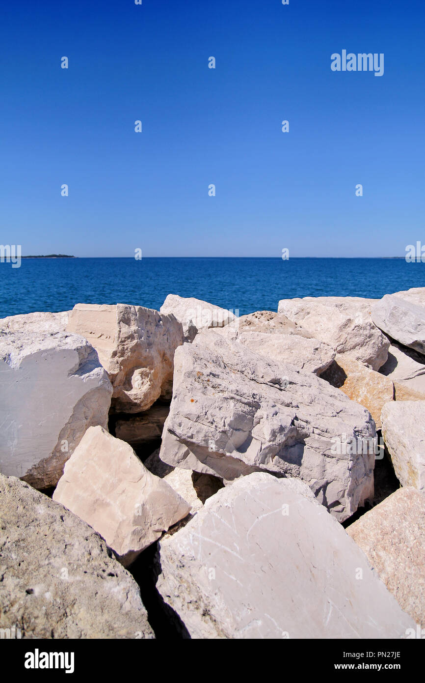 White rocks and stones with blue sea and sky in the landscape ...