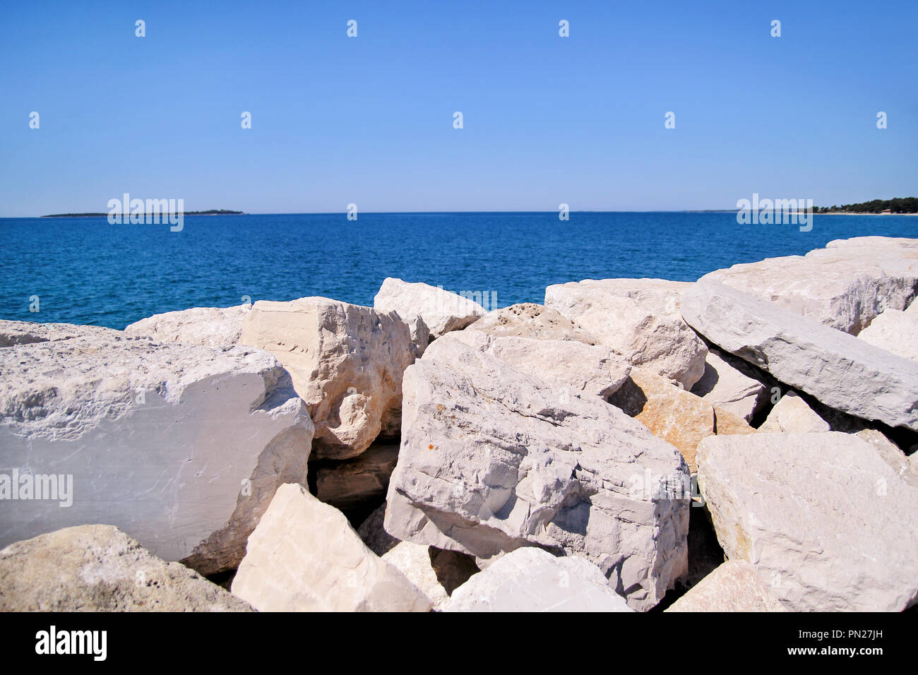 White rocks and stones with blue sea and sky in the landscape ...