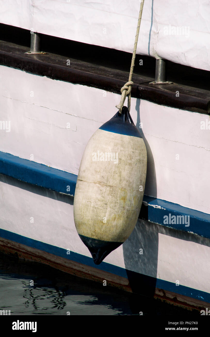 Buoys and anchor ropes, close up. White buoys on fishing boat anchored ...
