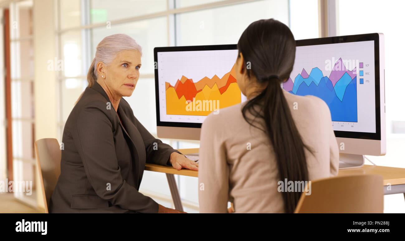 Two office professionals talk about their company's statistics Stock ...