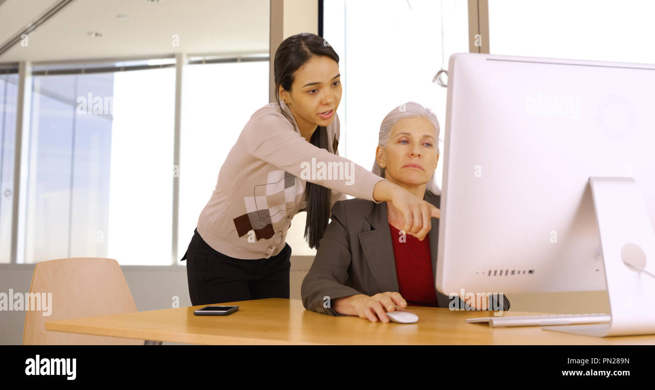 Two businesswomen use the computer Stock Photo - Alamy